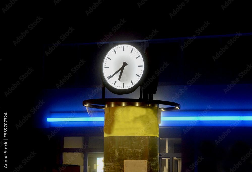 clock above a cylinder-shaped poster surface with lighting. large ...