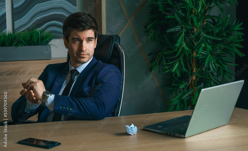 Angry businessman working with laptop in modern office. Crumples and ...