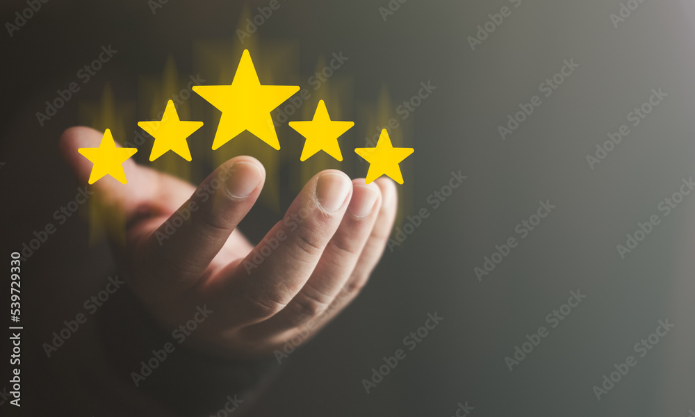 Hand of the customer or client holding the stars to complete five stars ...