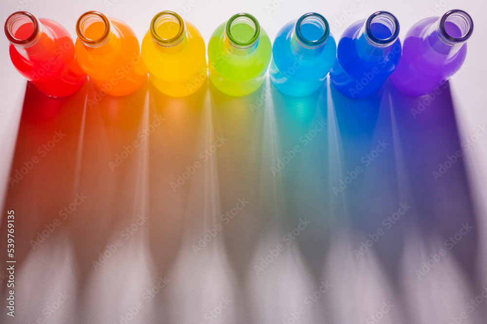 Rainbow colors in bottles with colored liquids. Rainbow shadows and ...