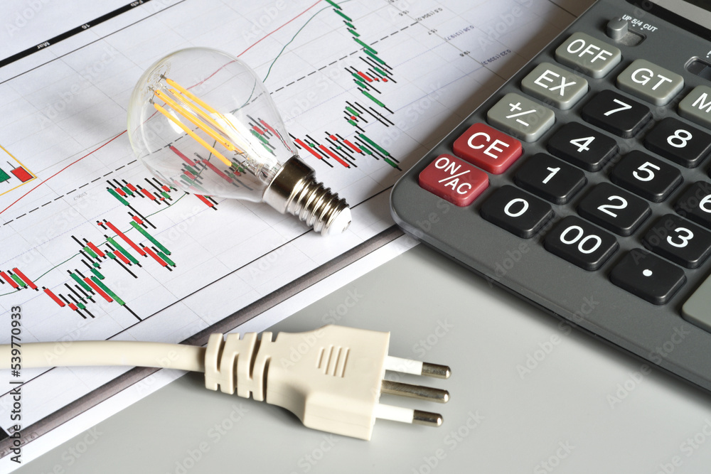 Closeup of energy save light bulb, calculator and electric plug over ...