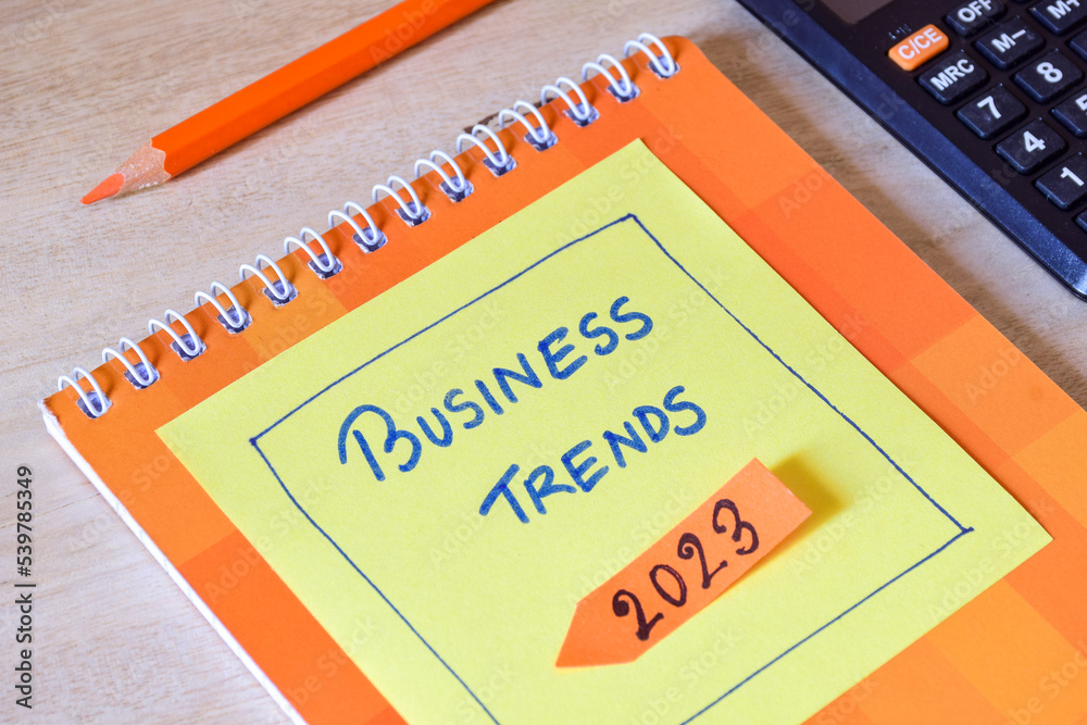 Business trends for the year 2023 handwritten on sticky notes on wooden ...