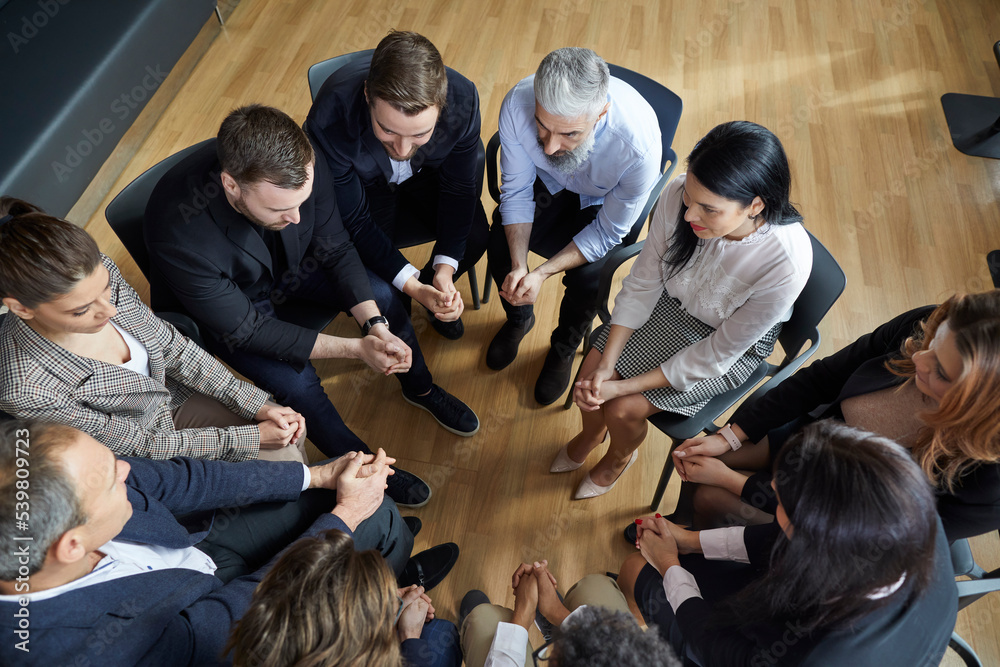 Business people in circle talking during informal brainstorming session ...
