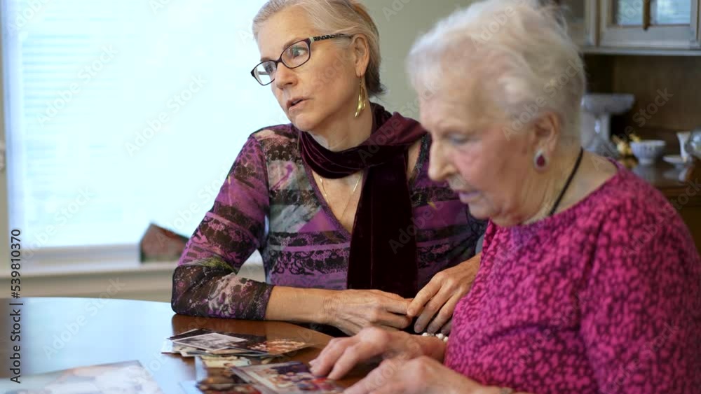 Senior elderly woman looking at old photos and remembering memories ...