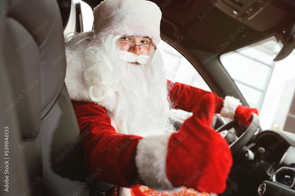 Santa sitting behind the wheel of a car shows a thumbs up - a class ...