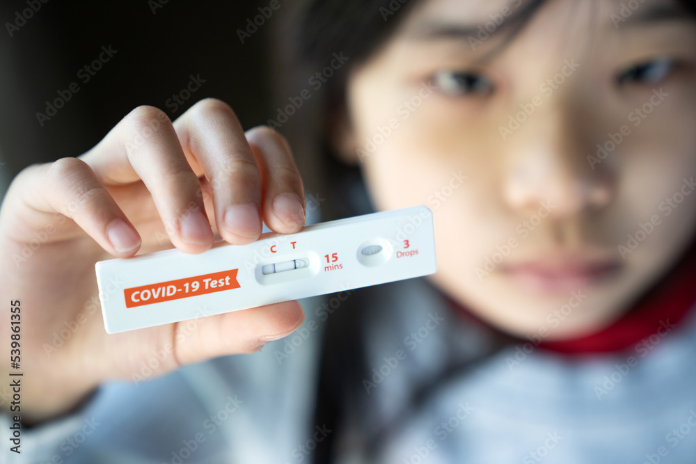 Little girl is showing positive results on rapid antigen test kit for ...