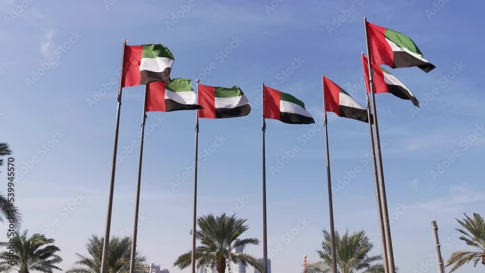 National symbol of United Arab Emirates flags in blue sky background ...