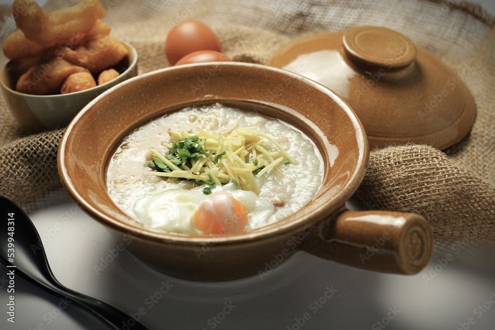 Hot Chinese pork congee top with soft boiled eggs served in a Chinese ...