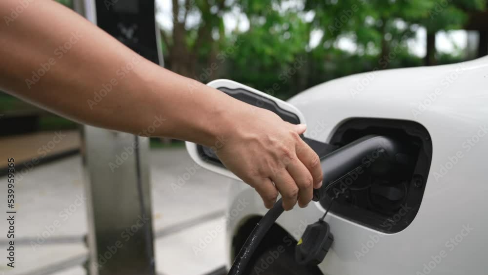 Stockvideo Progressive man install power cable plug to his electric ...