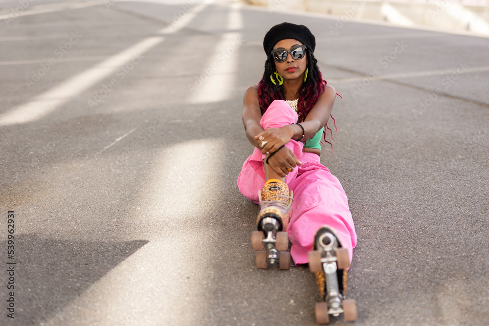 Black woman on roller skates riding outside on urban street. Modern ...
