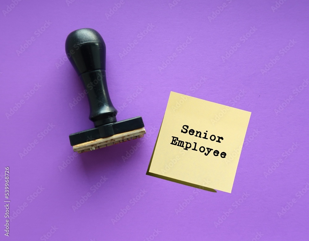 On purple background, rubber stamp with words SENIOR EMPLOYEE, concept ...