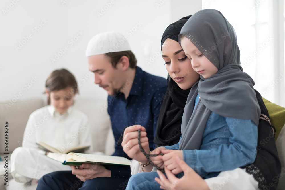 Traditional muslim family parents with children reading Quran and ...