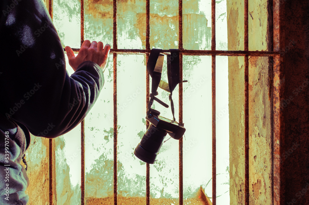 Man and camera locked up behind bars - Photo reporter in a old rusty ...