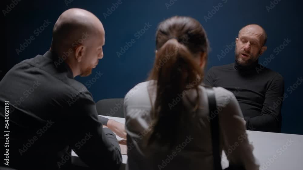 Lawyer enters room and sits down next to client. Police officers ...