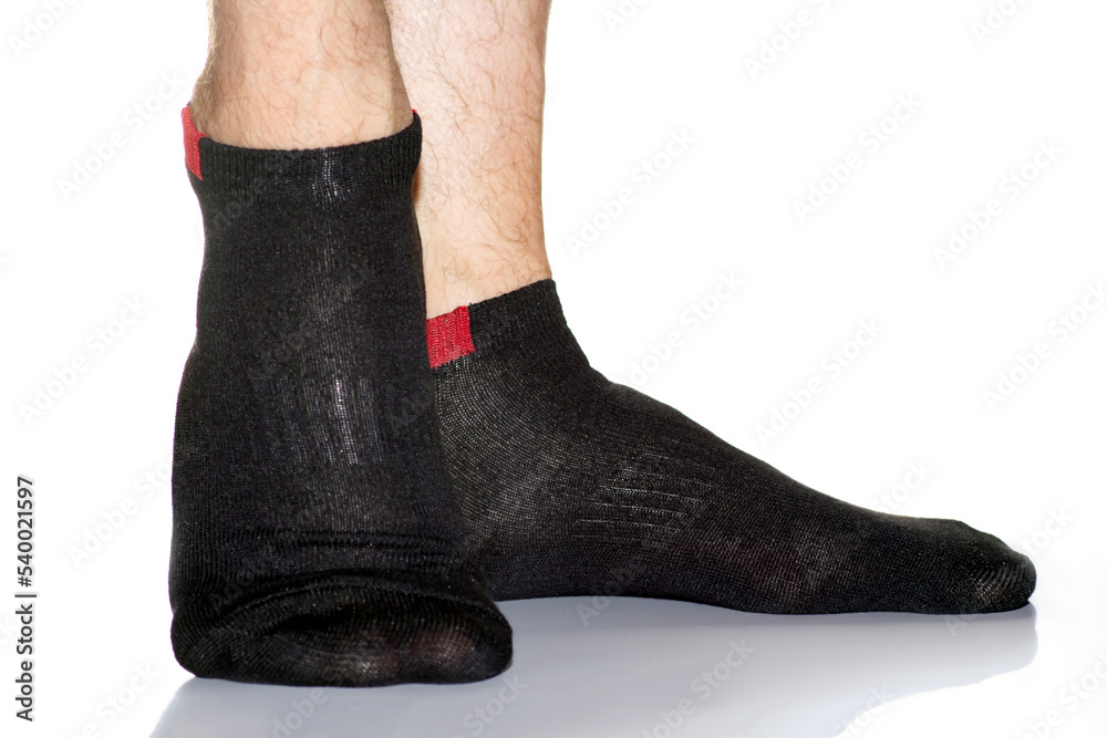 black men's socks with a red insert on the feet, legs in socks on a ...