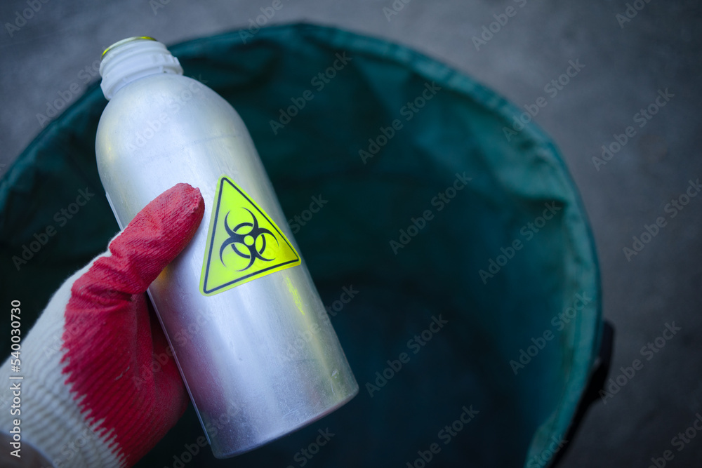 Foto de Disposal of hazardous waste. The hand holds an aluminum bottle ...