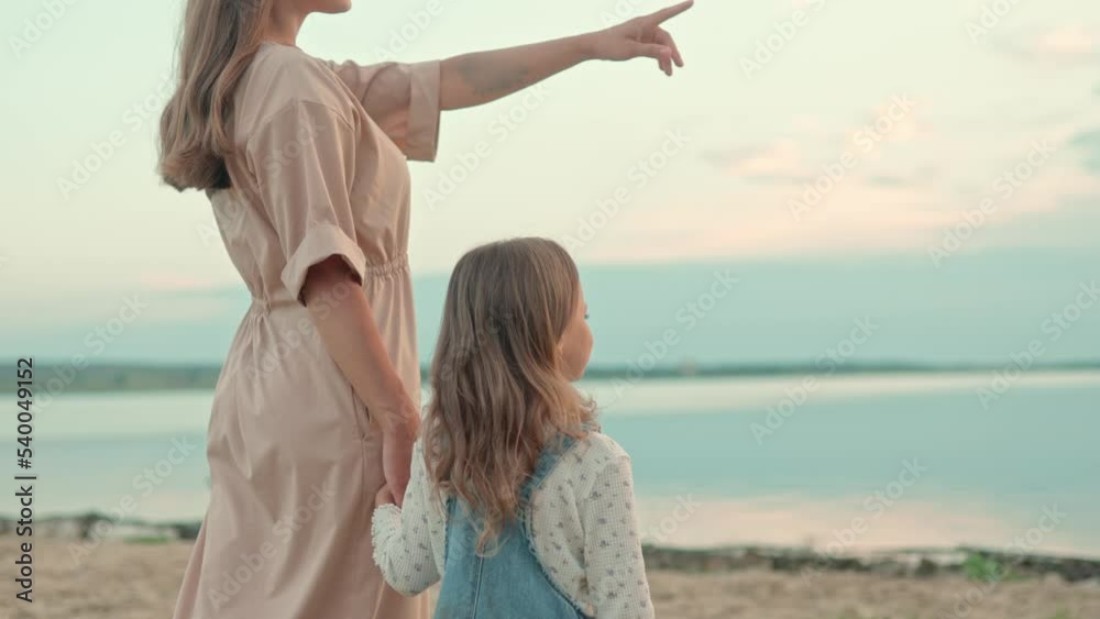 Back view. Happy pretty cute little girl holding hand of her mother and ...