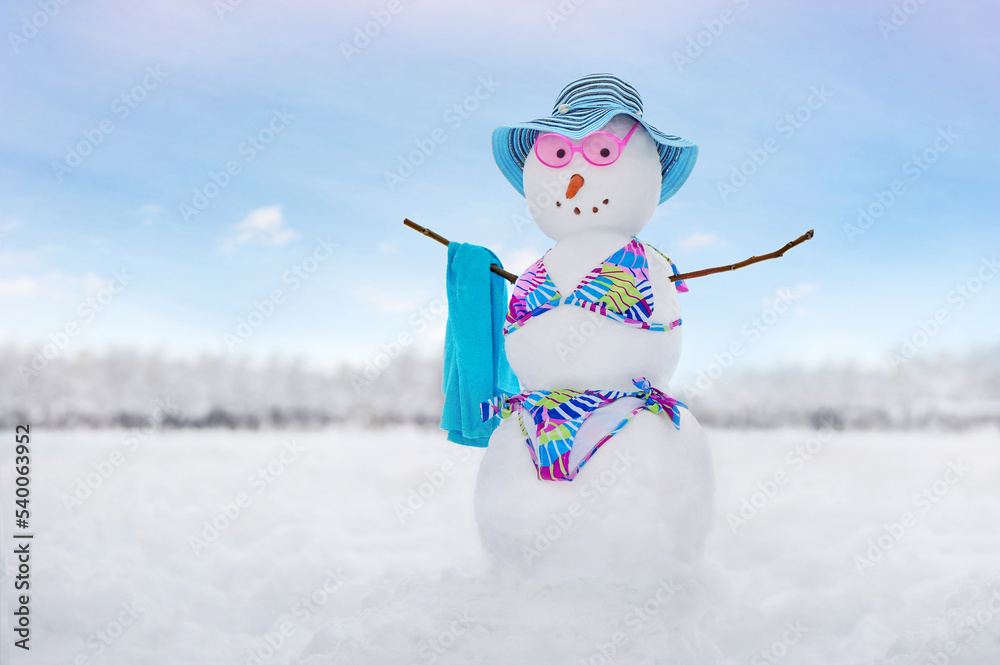 Snowman wearing swimsuit and a hat getting tanned at the winter resort ...