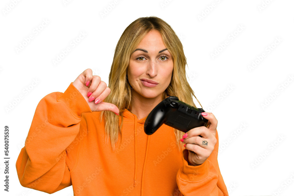Young caucasian gamer woman holding a game controller isolated on green ...