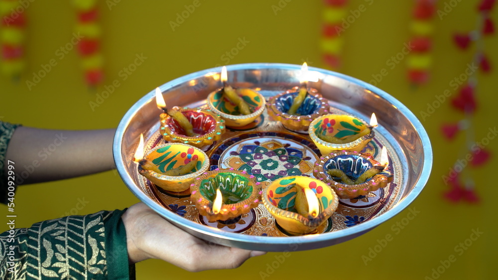 Indian woman or girl holding lit traditional clay diya or oil lamp with ...