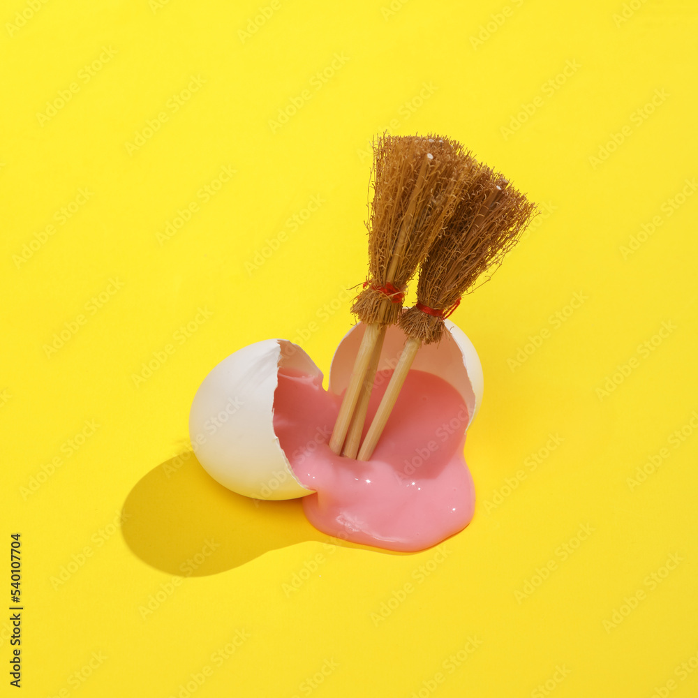 Creative layout with witch brooms hatched from egg on bright yellow ...