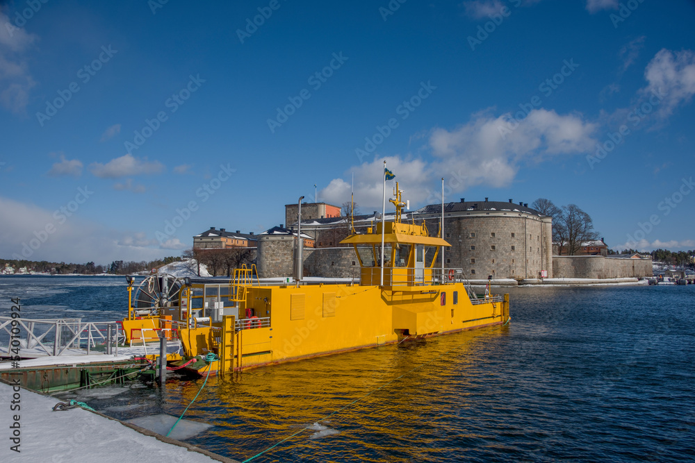 Winter view in Stockholm archipelago town Vaxholm, icy lake, snow, pier ...