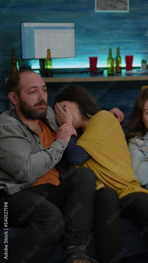 Vertical video: Multi-racial friends screaming while watching thriller ...