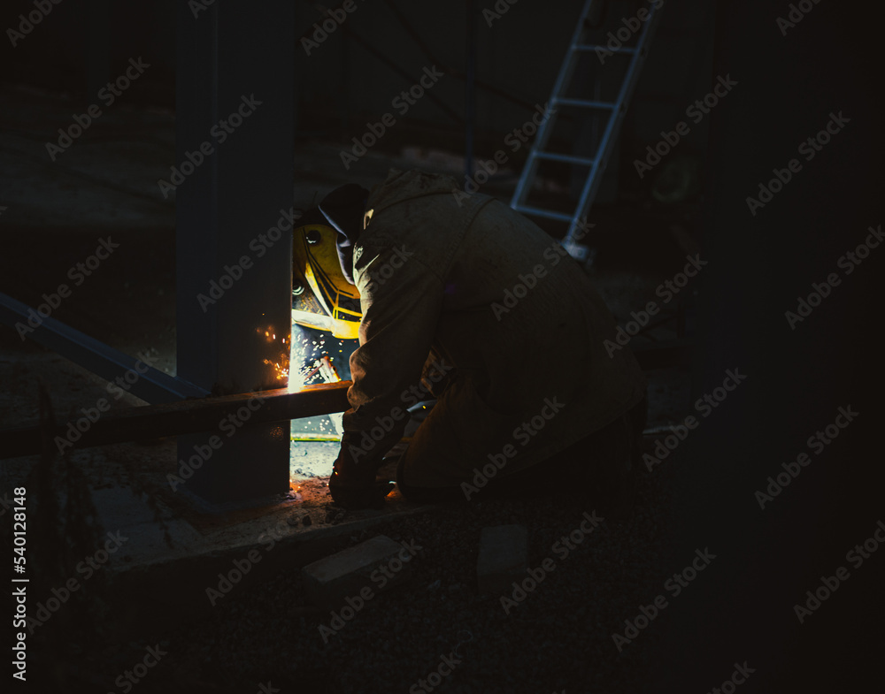 Welder at work side view. A man in a protective welding mask. The ...