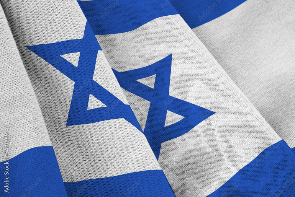 Israel flag with big folds waving close up under the studio light ...