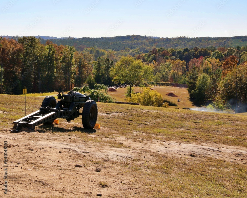 Historic Howitzer cannon over looking a smoke filled field after firing ...