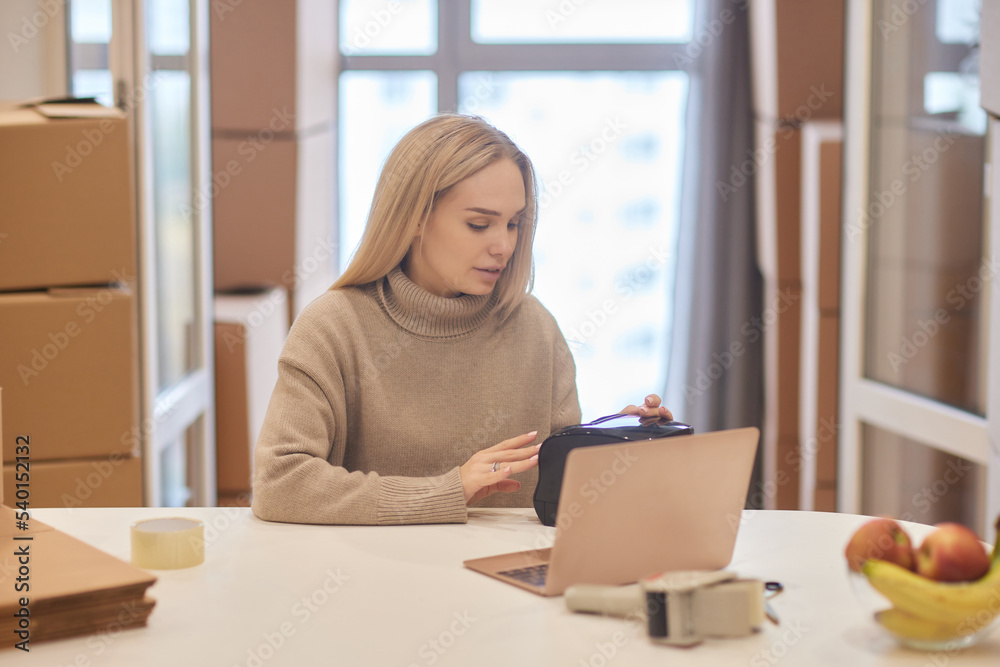 young blonde woman barcode printer and boxes on the background for ...