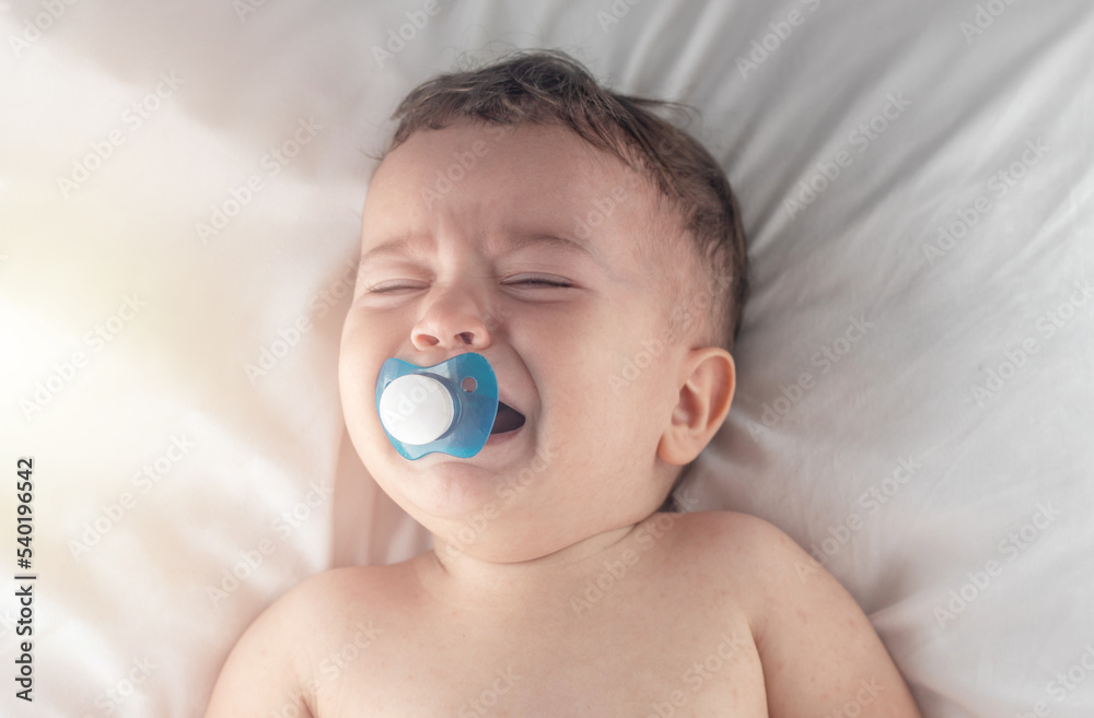 unhappy upset crying baby toddler infant toddler with pacifier in mouth ...