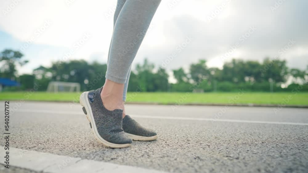 Side closeup female legs doing ankle rotation, warm up exercise on the ...