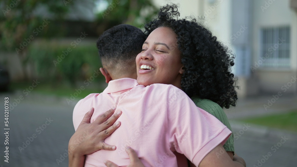 Two happy people embracing celebrating reunion. Young woman hugging ...