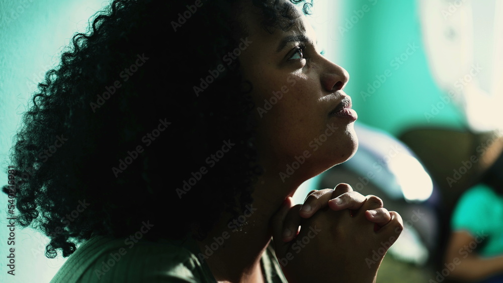 African American woman praying to God. A spiritual black hispanic girl ...