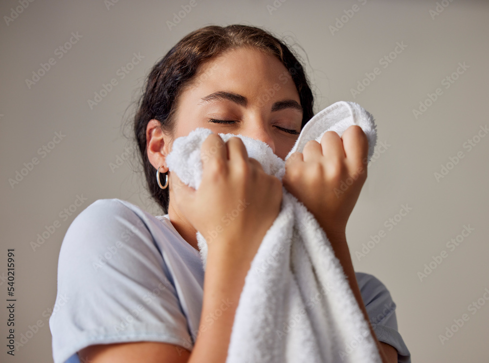 Woman smelling a clean towel after doing laundry at her home, hotel or ...