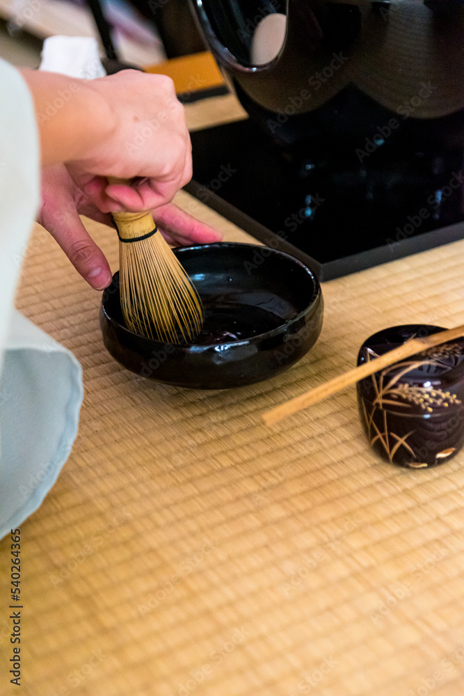 Japanese woman, tea master, Sen Rikyu, hands purifying a chasen, bamboo ...