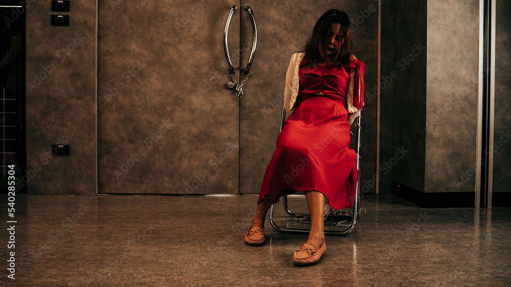 Fotografia do Stock: A woman wearing a red dress tied her hands to a ...