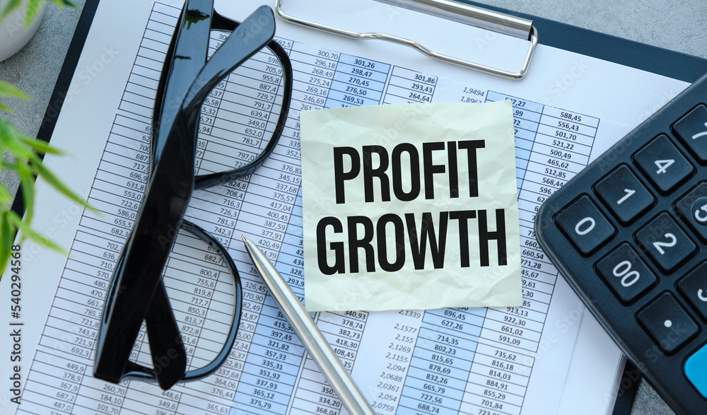 PROFIT GROWTH text sign in a card placed on pink background with pen ...