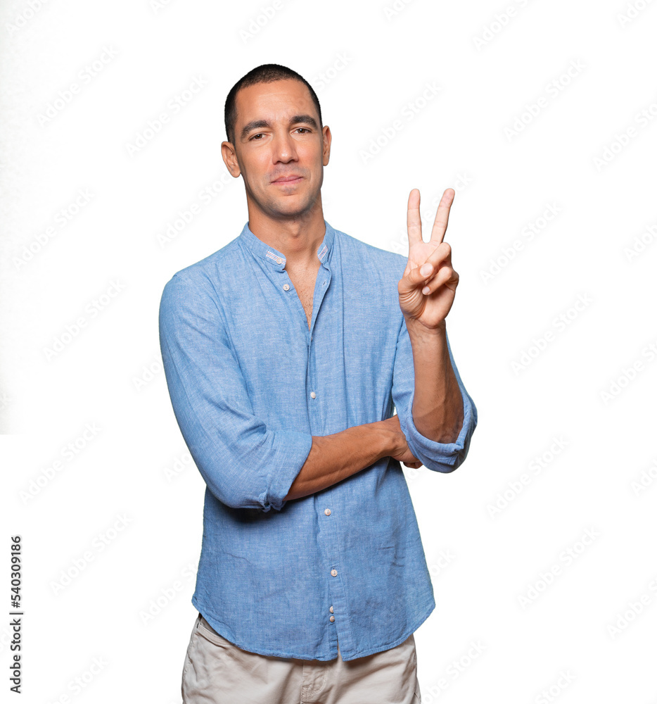 Young man making a number two gesture Stock Photo | Adobe Stock