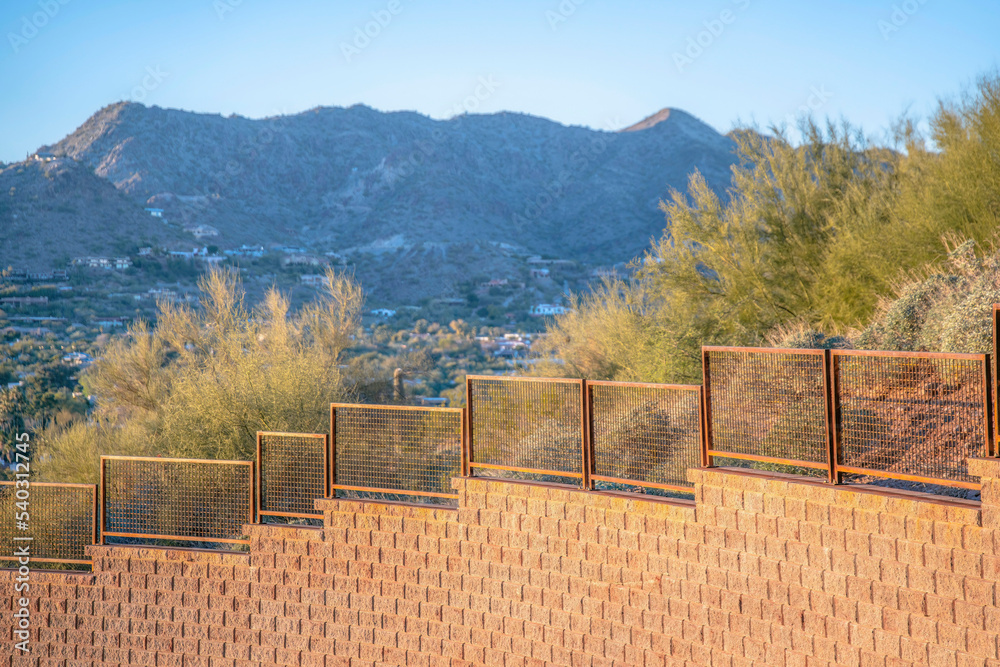 Phoenix, Arizona- Slope with concrete retaining wall and metal fence at ...