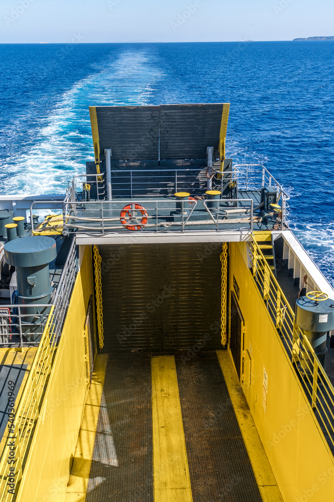 Yellow ramp and draw bridge on a ferry carrying trucks, buses and cars ...