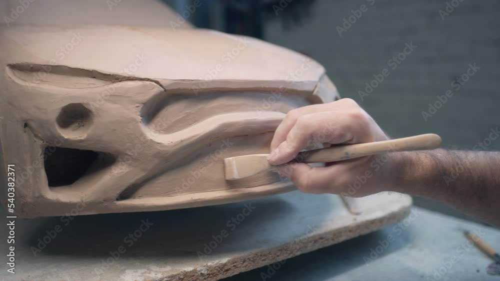 Video Stock Hands of a male designer works on the sculpture of a car ...