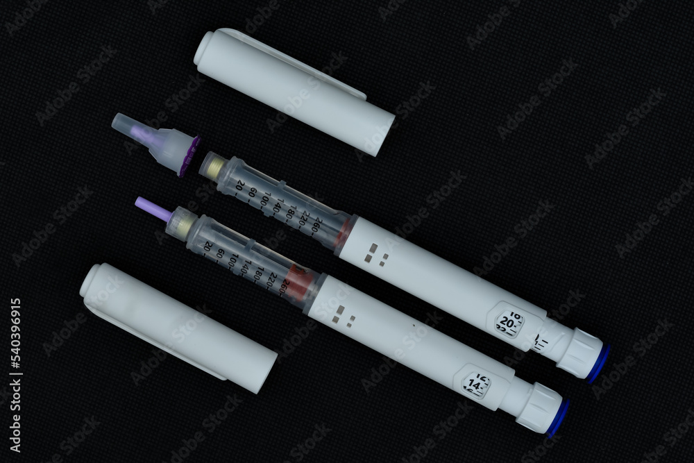 Insulin pen isolated on black background. Medical devices are used for ...
