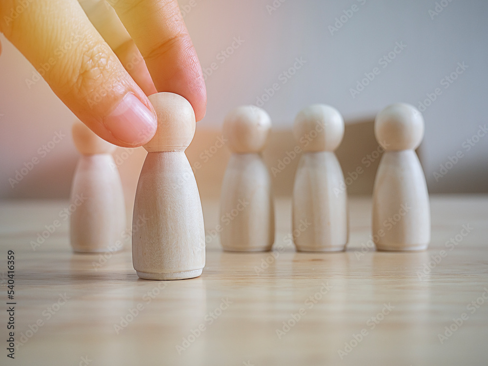 Hand choose a wooden figure to in front of line with each other figure ...