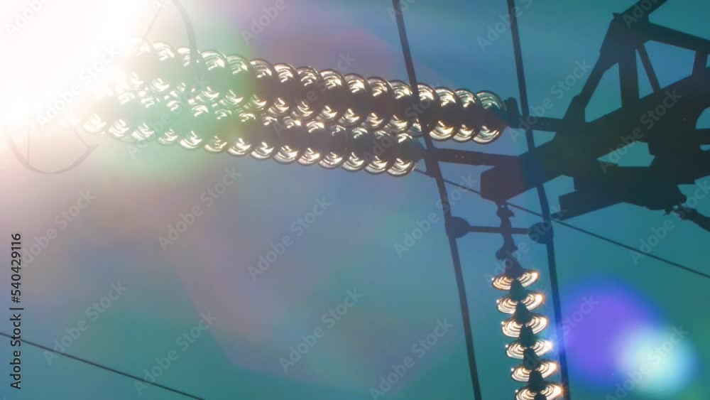 Power lines with sun rays on blue sky. High voltage substation ...