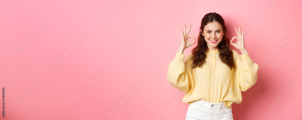 Young confident girl showing okay signs and smiling, praise something ...