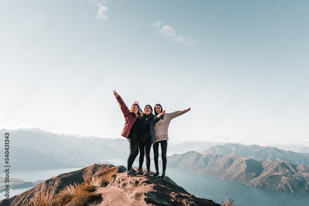 Three Caucasian Girls In Black Pants Looking At Camera With Arms Outstretched Smiling And Happy