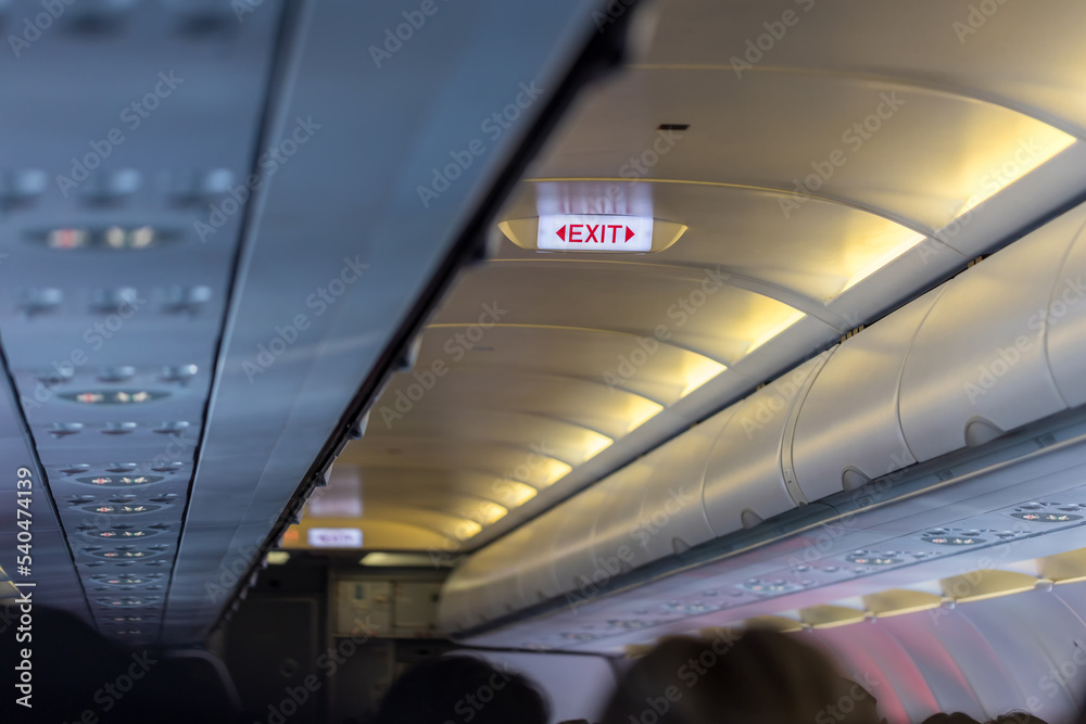 Exit sign in passenger airplane. Emergency exit sign on airplane. Exit ...