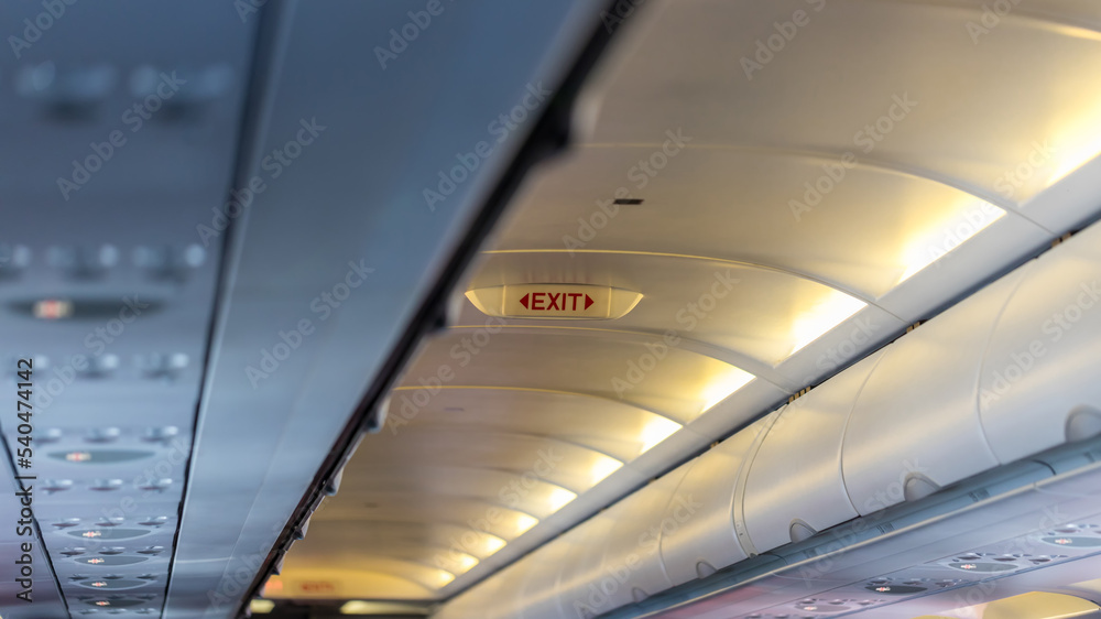 Exit sign in passenger airplane. Emergency exit sign on airplane. Exit ...